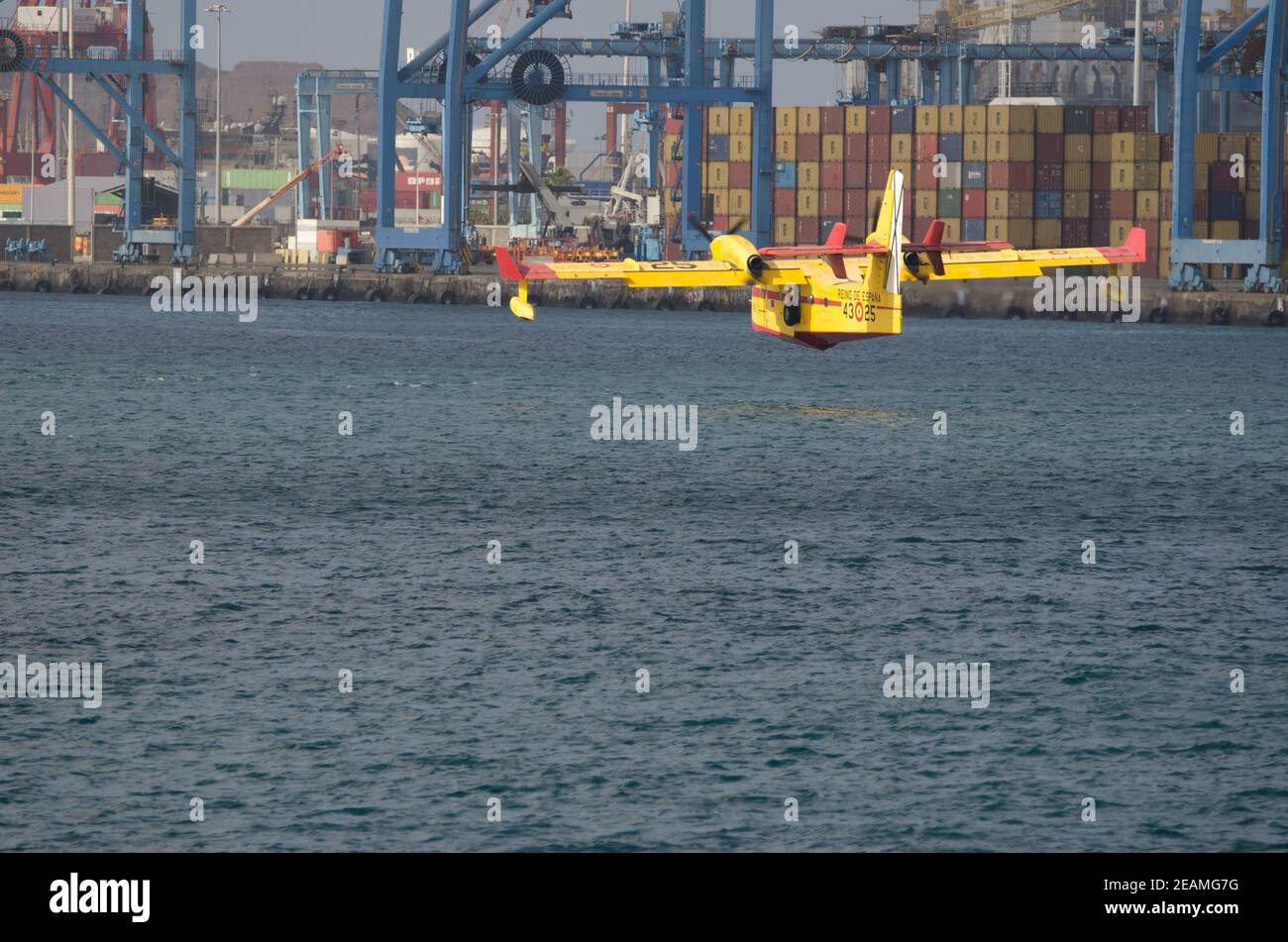 Fire-fighting plane collecting sea water to extinguish a forest fire ...