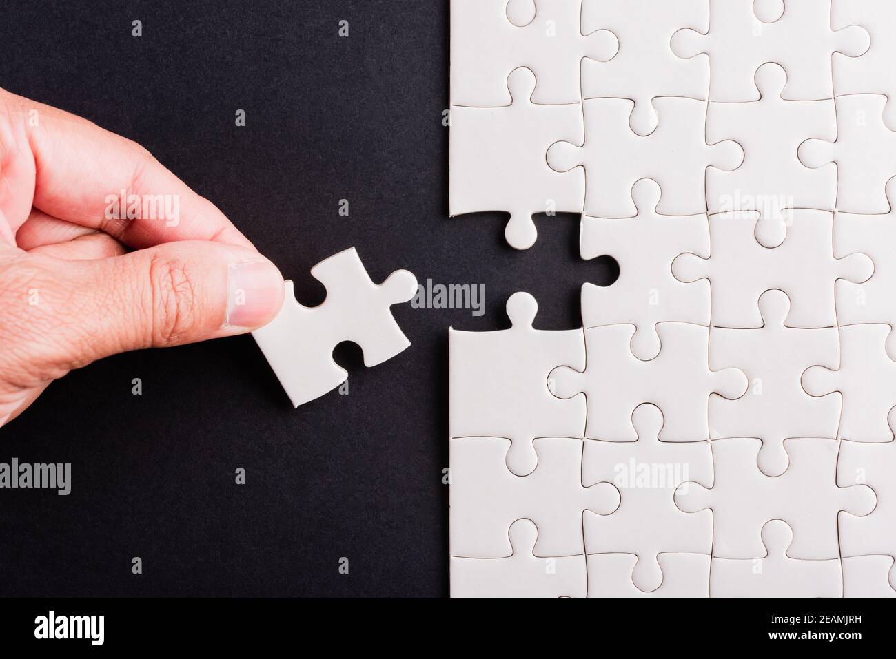 hand-holding last piece white paper jigsaw puzzle game last pieces put ...