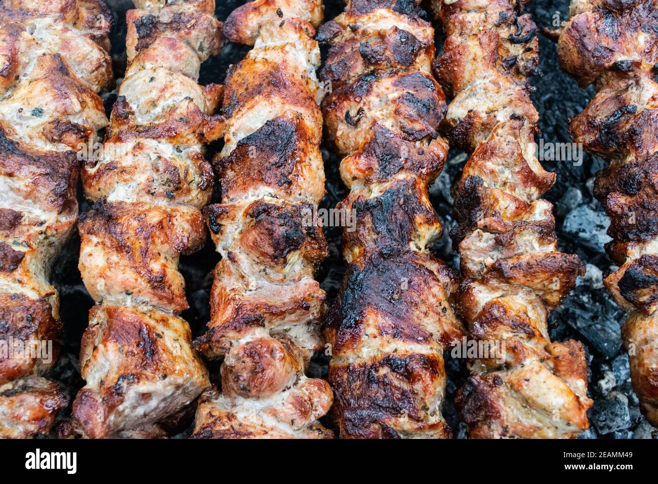 Frying pork on a skewer over a brazier. Turning meat over coals ...