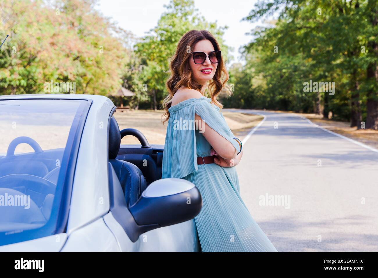 Attractive woman posing at convertible car. Happy pretty girl. Outdoor ...