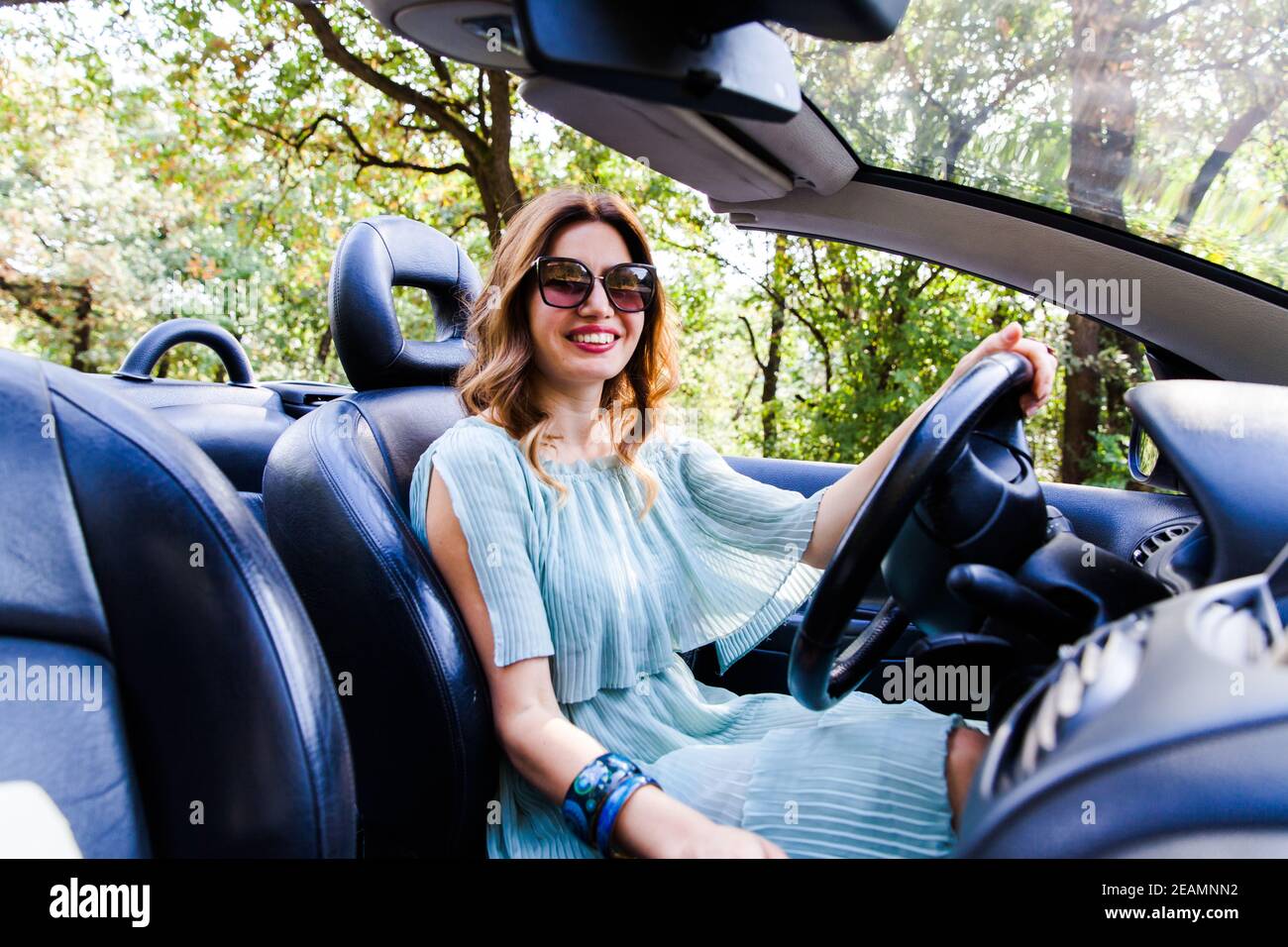 Beautiful young happy smiling woman driving convertible car. Cheerful ...