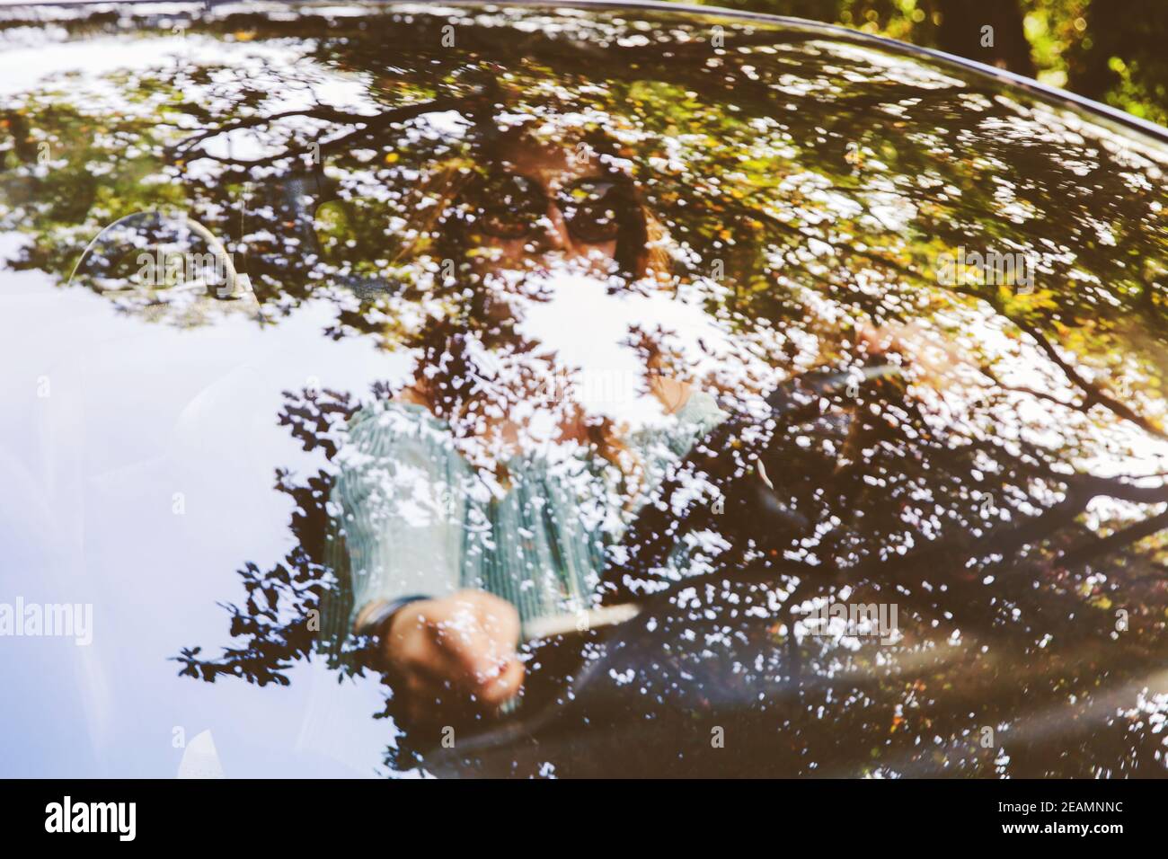 Woman driving convertible car in nature. Looking through windshield ...