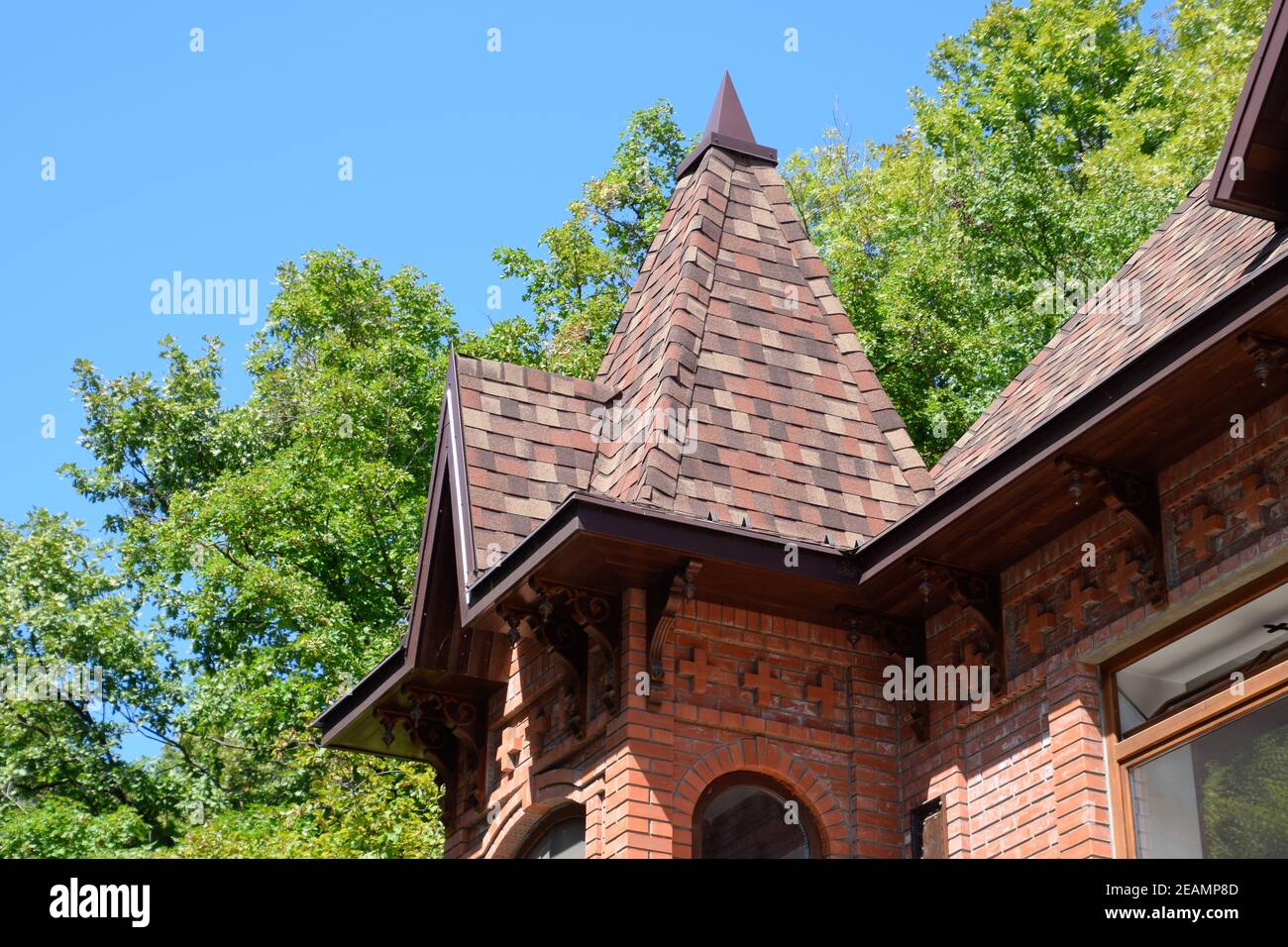 Part of the brick building of red brick and shingles on the roof Stock ...