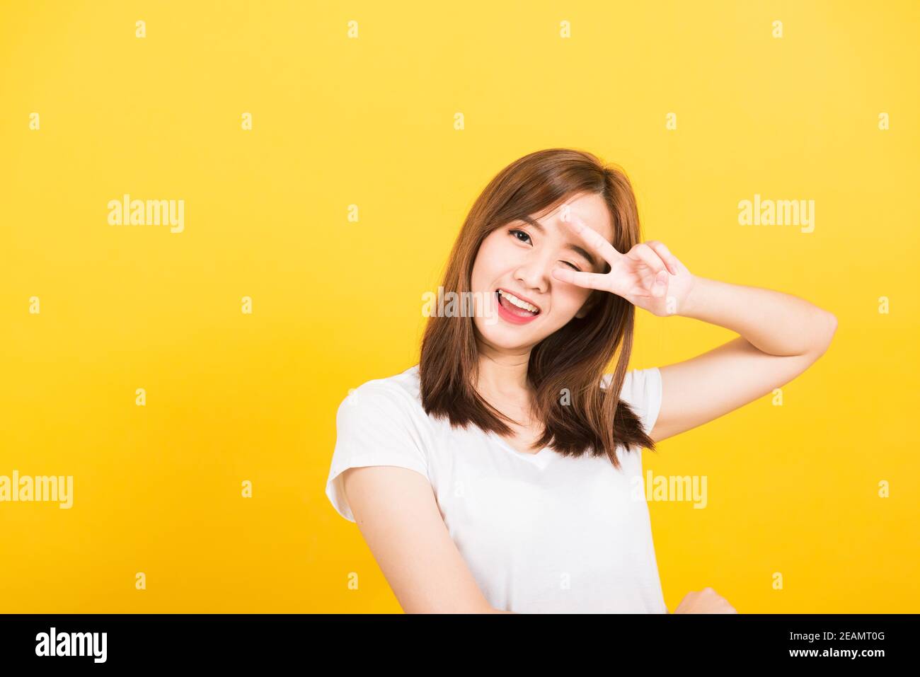 woman teen smile standing wear t-shirt showing finger making v-sign ...