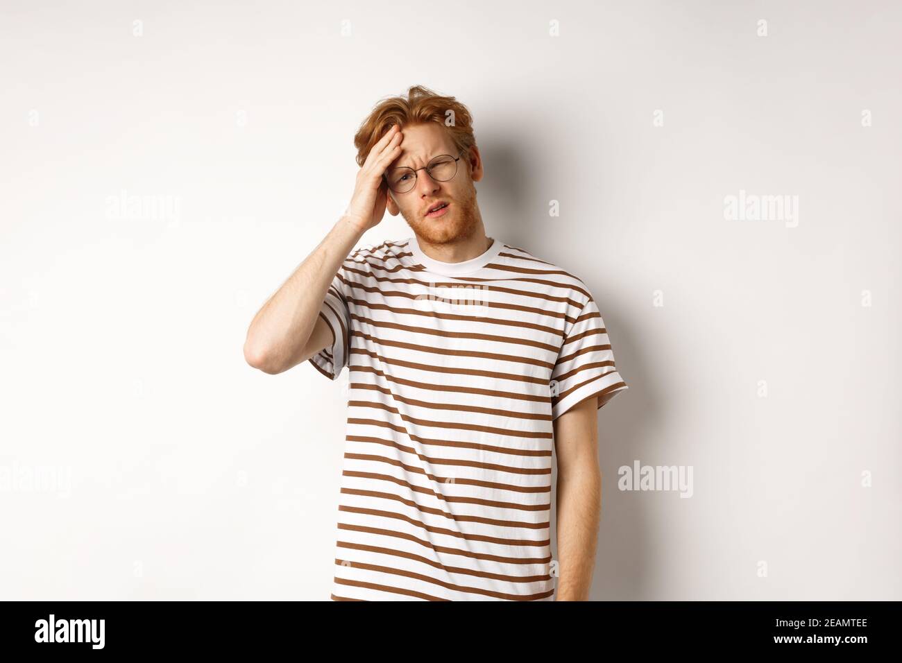 Tired young man student touching head, looking complex and tired ...