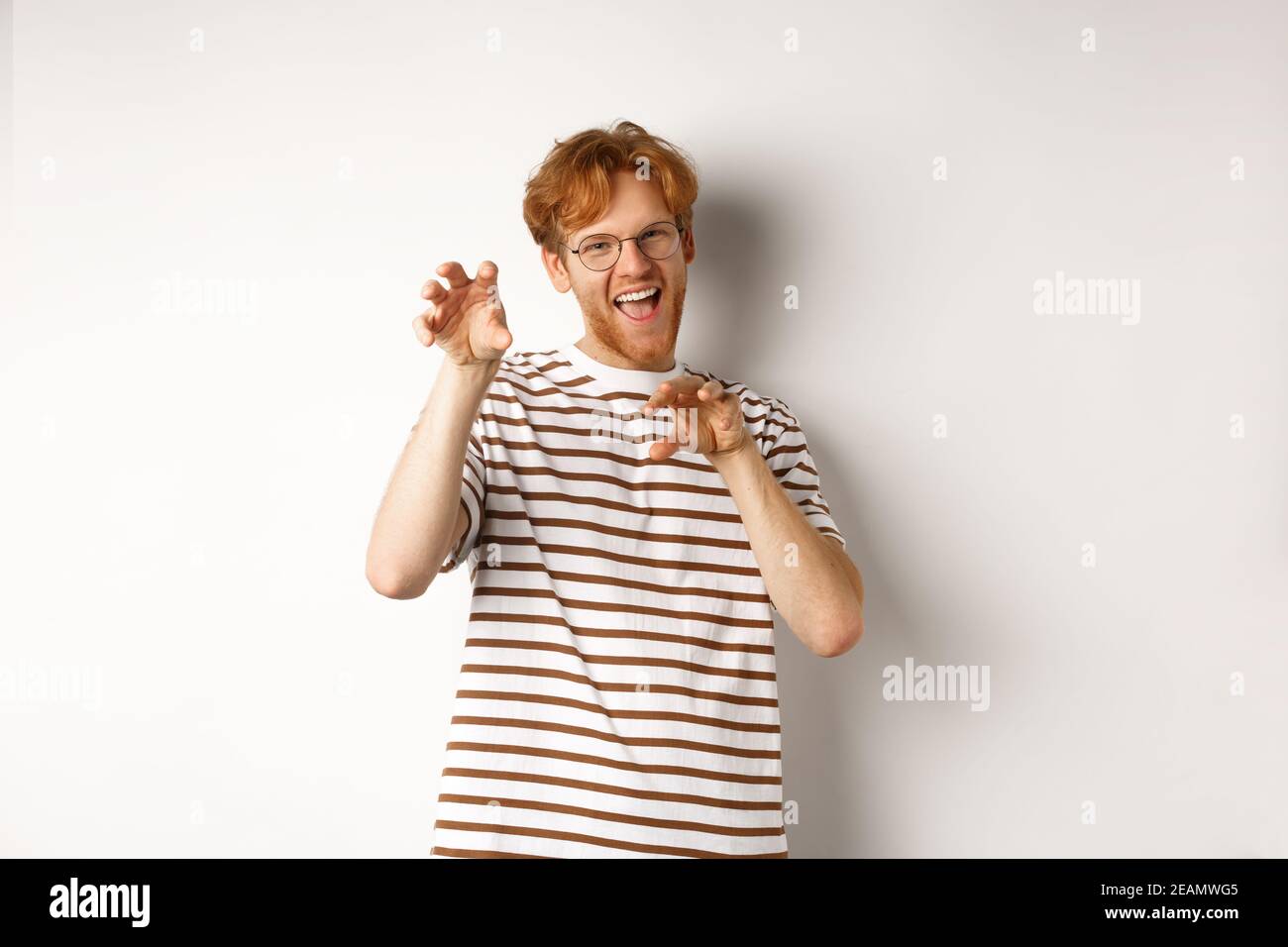 Funny young man with red hair and beard showing claws gesture and ...