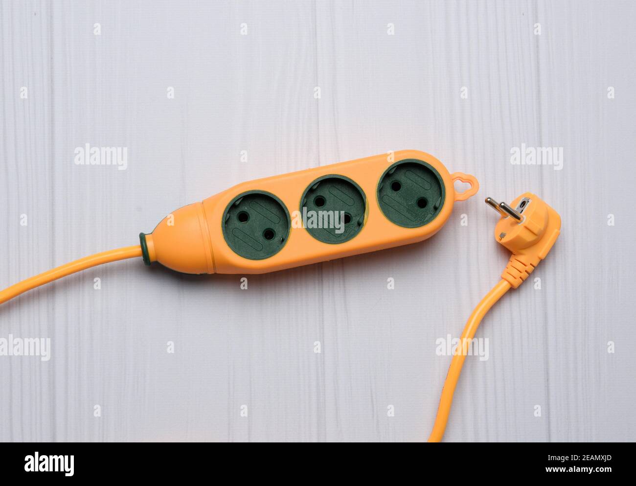 rubber orange power strip with three sockets on a white background ...