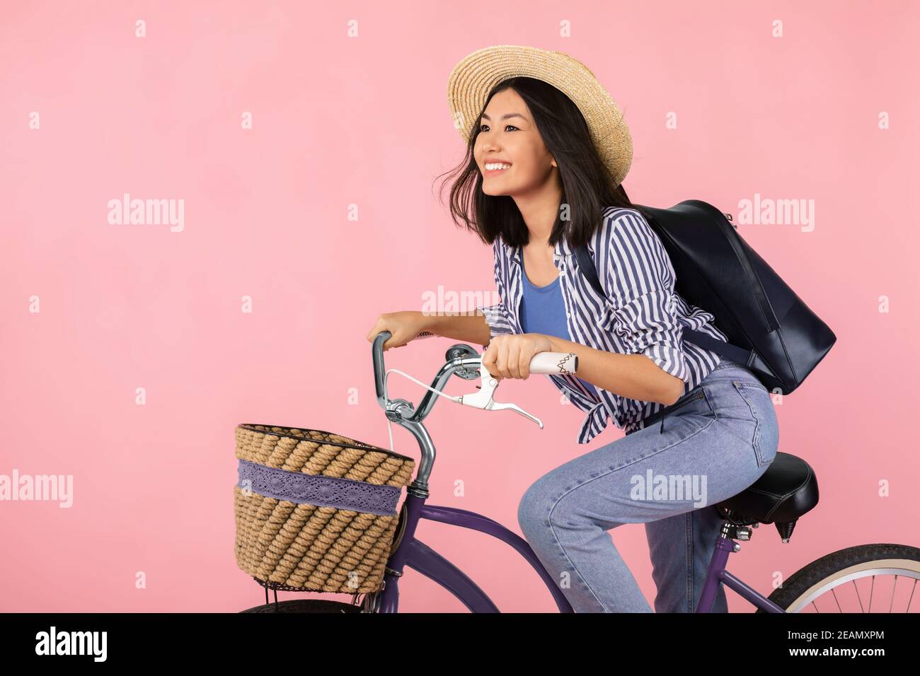 Charming asian woman riding bicycle with wicker basket Stock Photo - Alamy