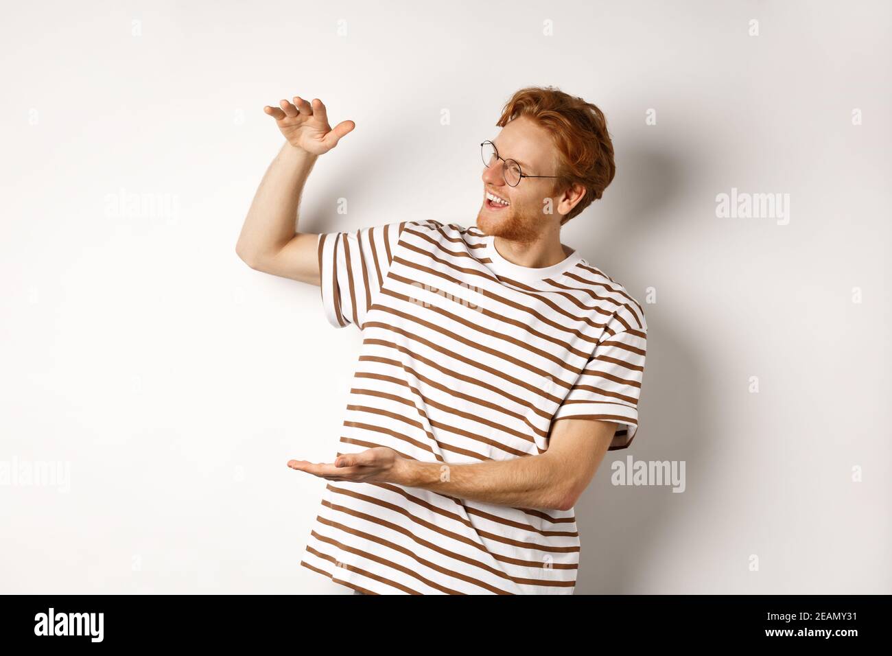 Happy and satisfied caucasian redhead man introduce something big ...