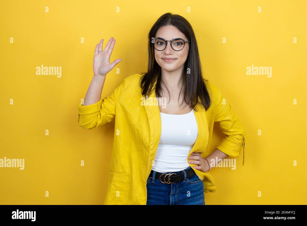 Young brunette businesswoman wearing yellow blazer over yellow ...