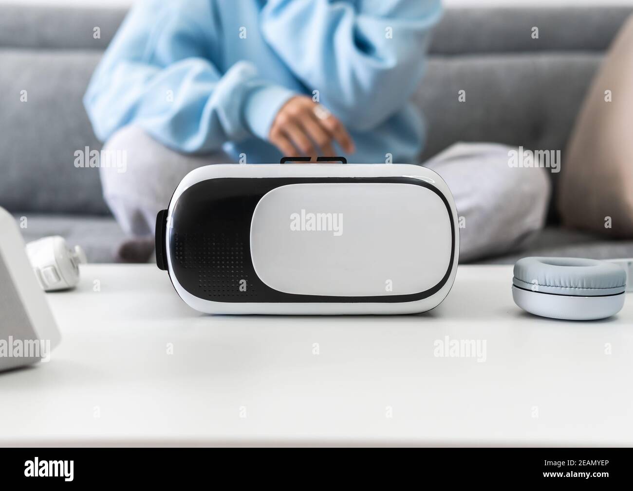 Female sitting on the couch in front of a table with virtual reality ...