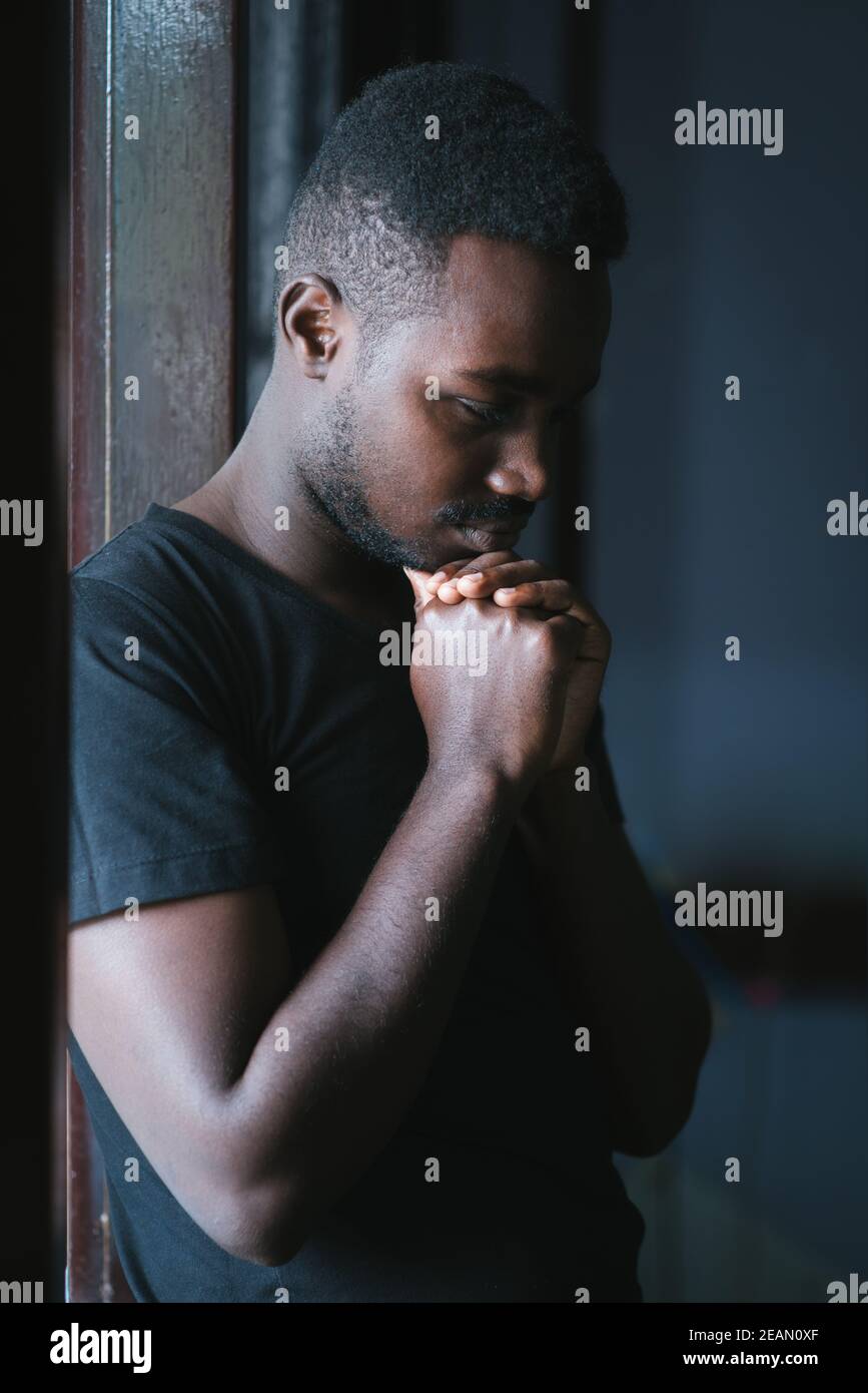 Sad african man in dark room , Low key style Stock Photo - Alamy