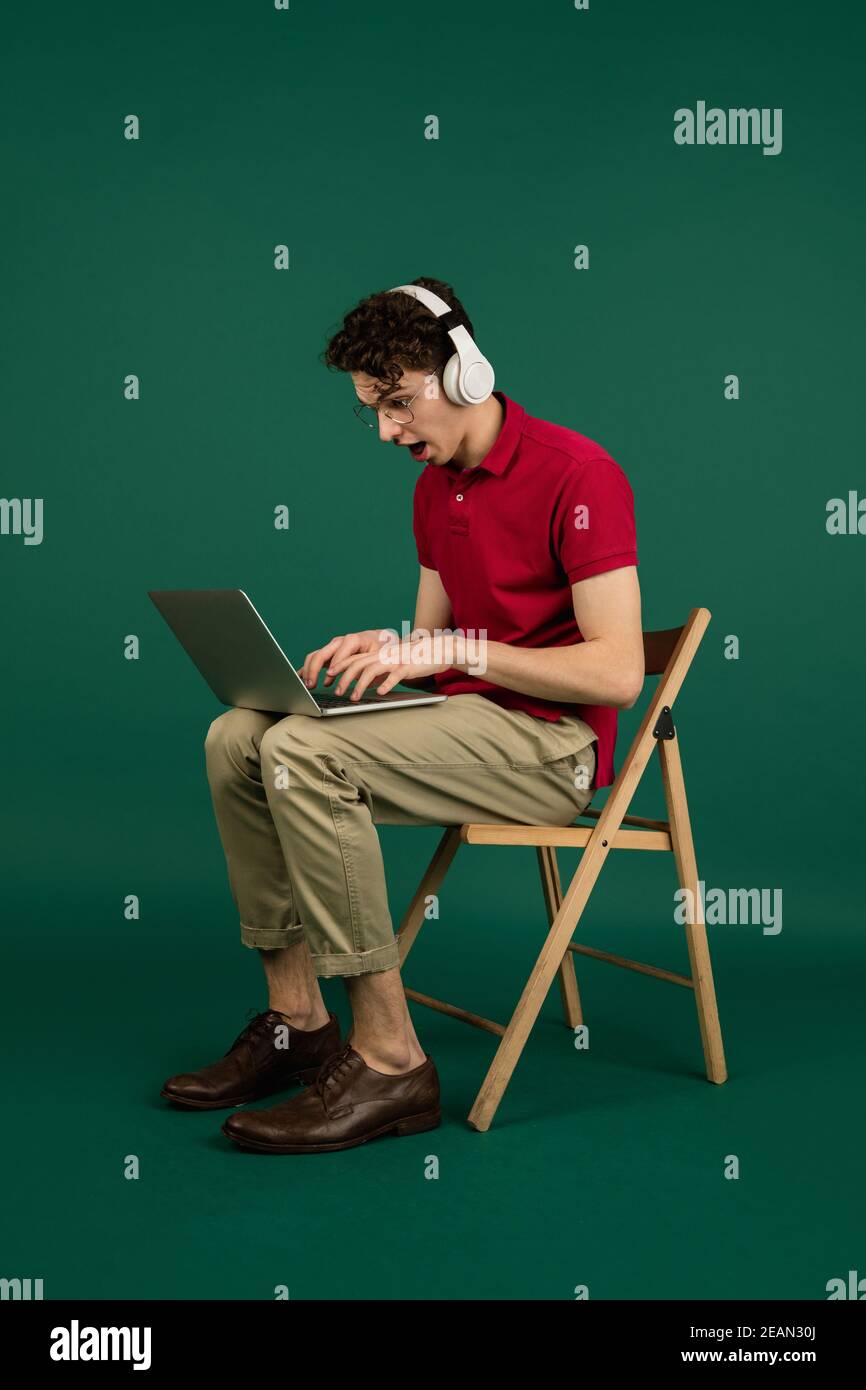 Typing text, listening to music. Caucasian handsome man's portrait on ...