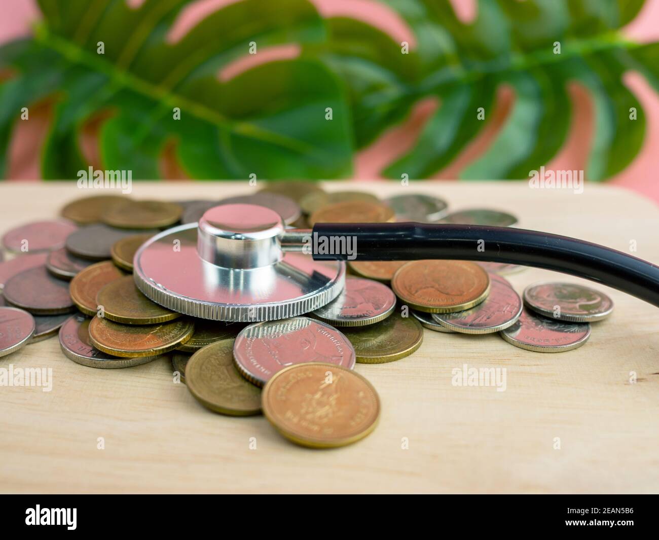 A stethoscope placed on a pile of money is a financial exam concept ...