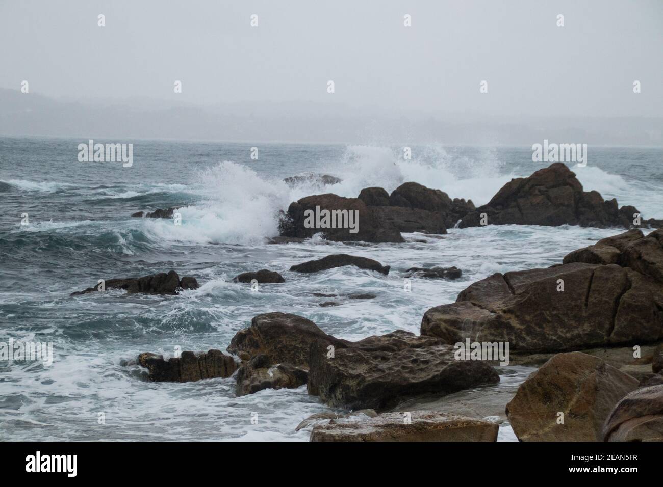 Wavy sea and rocky beach Stock Photo - Alamy