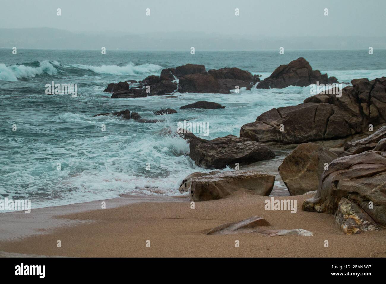 Wavy sea and rocky beach Stock Photo - Alamy