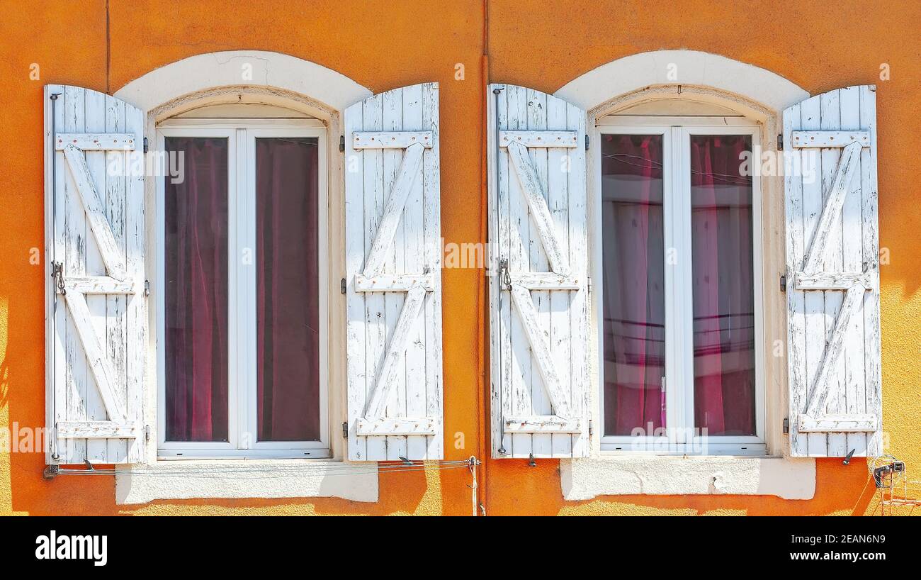 Detail of an open wooden vintage rustic windows on red cement old wall ...