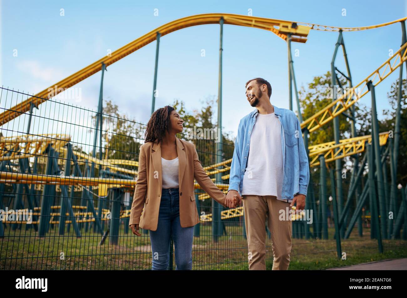 Love couple at roller coaster in amusement park Stock Photo - Alamy