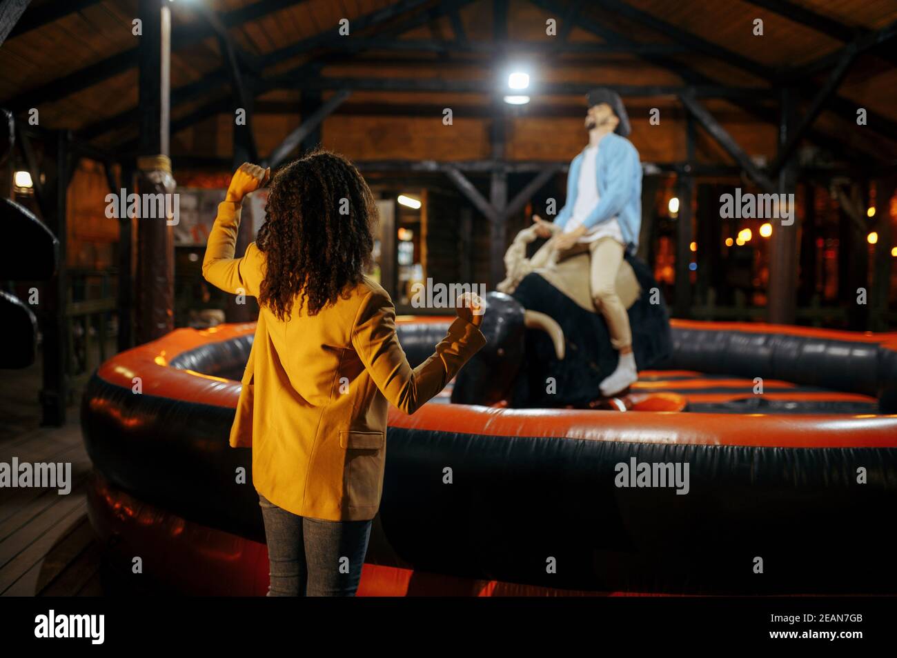 Love couple having fun on rodeo attraction in park Stock Photo - Alamy