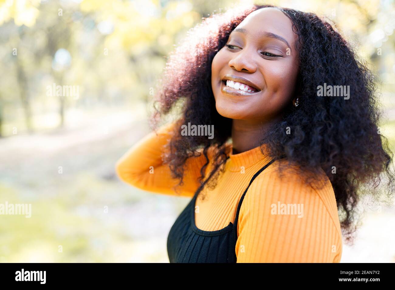Cute black woman smiling in a park Stock Photo - Alamy