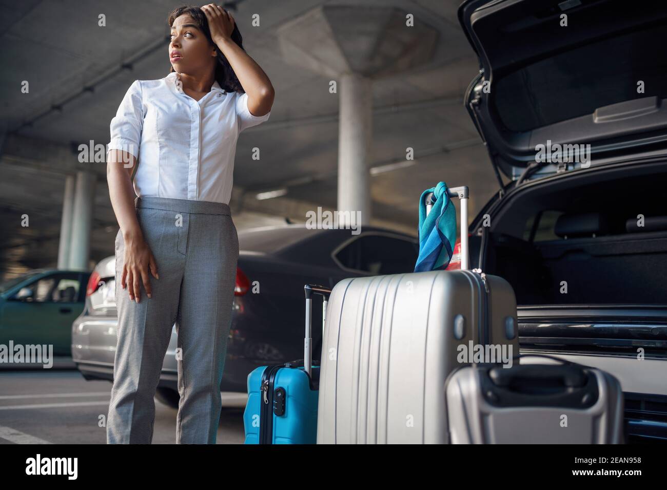 Young woman with suitcases in a panic, car parking Stock Photo - Alamy