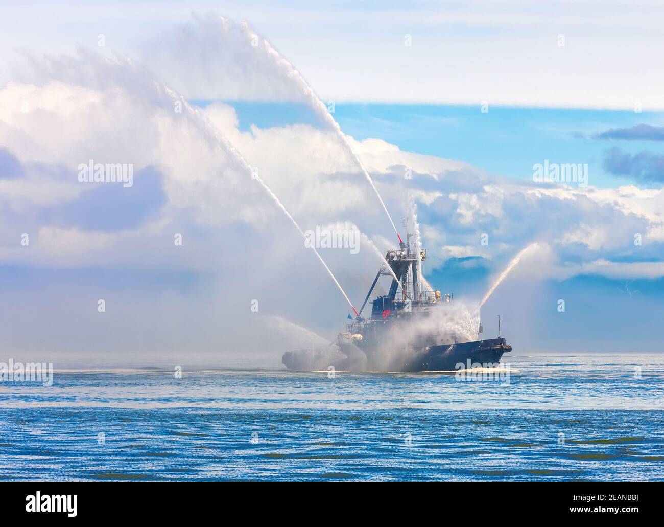 Floating tug boat is spraying jets of water Stock Photo - Alamy