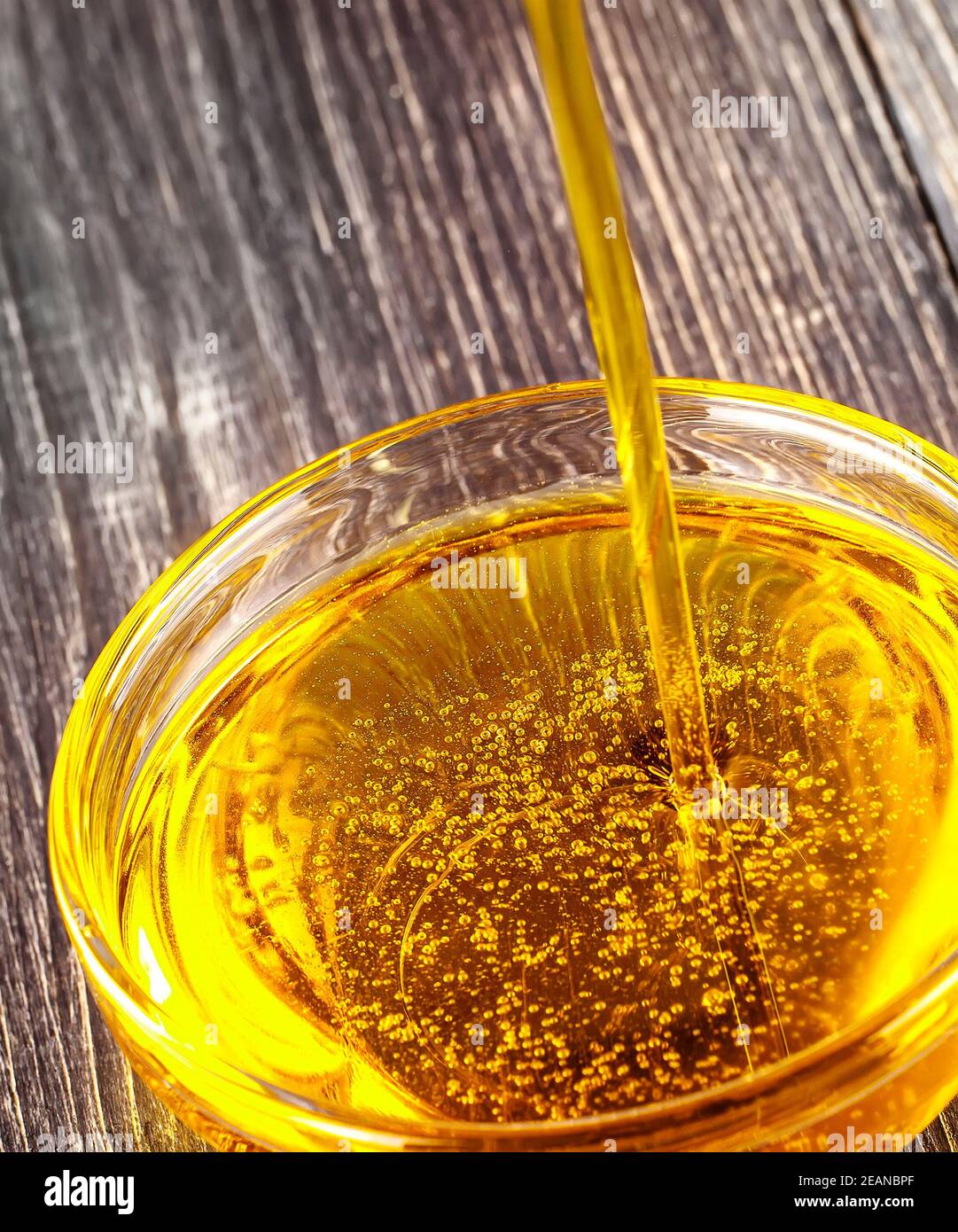 Pouring cooking oil a small glass cup on old wooden table Stock Photo ...
