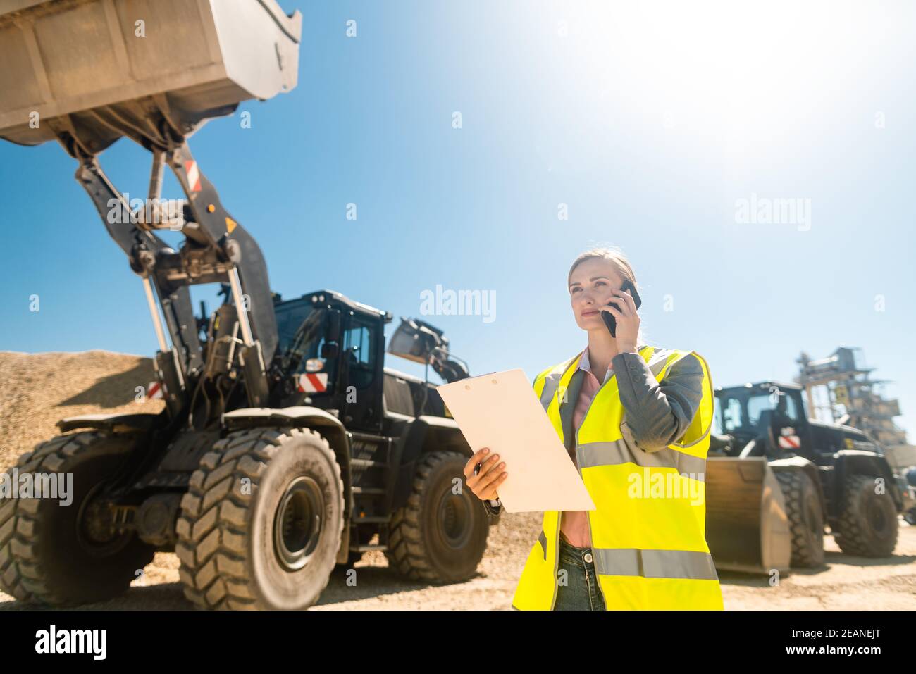 Worker woman with phone and clipboard in mine or quarry Stock Photo - Alamy