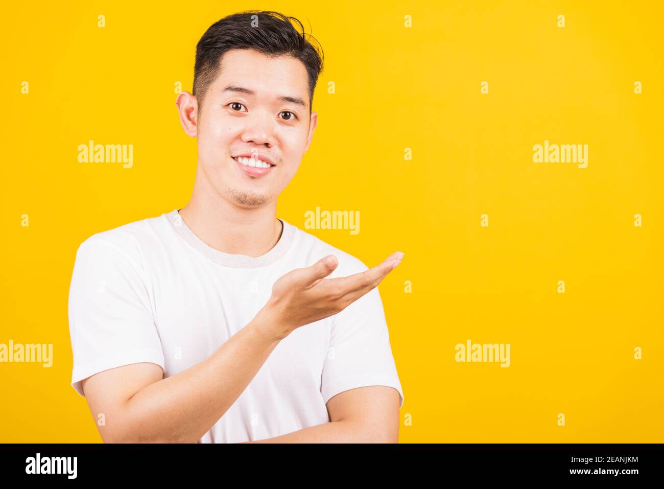 handsome young man smiling standing show something on hand Stock Photo ...