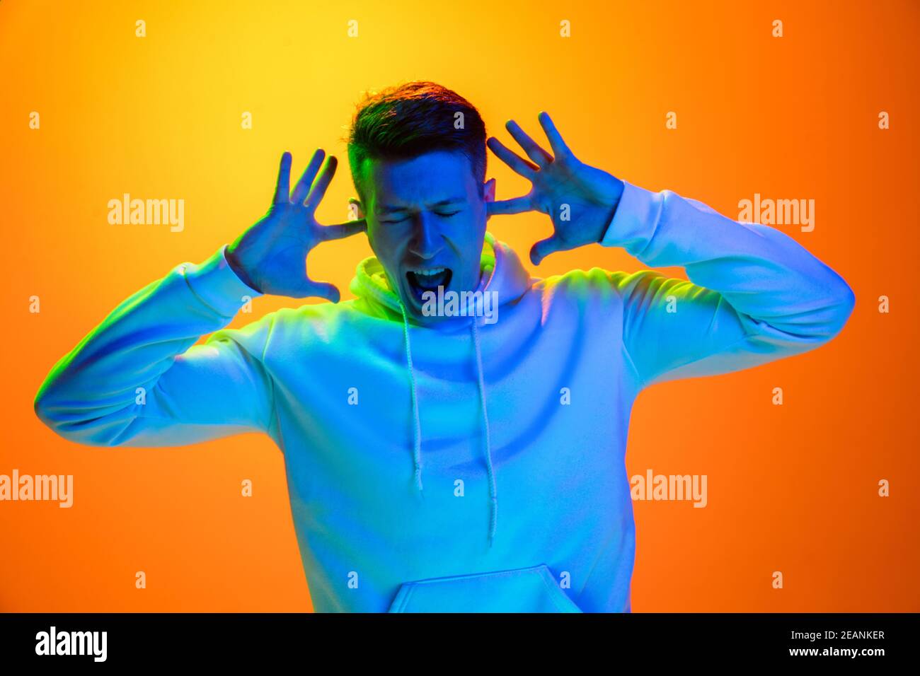 Angry screaming. Caucasian man's portrait isolated on yellow studio ...