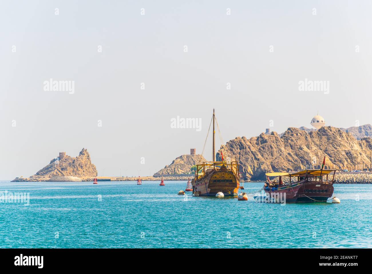a pair of dhows - traditional arab ships - is heading to the sea from ...