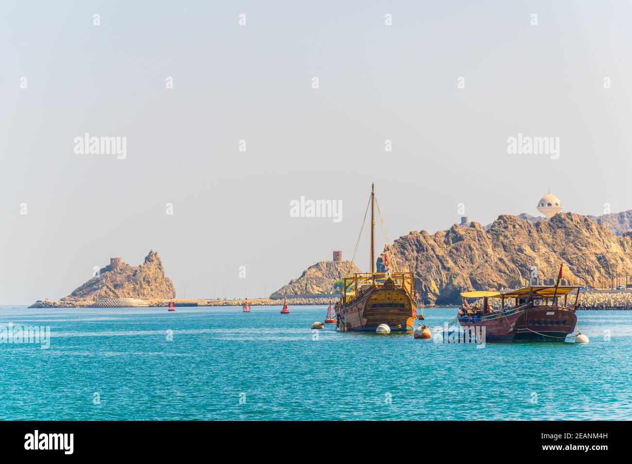 a pair of dhows - traditional arab ships - is heading to the sea from ...
