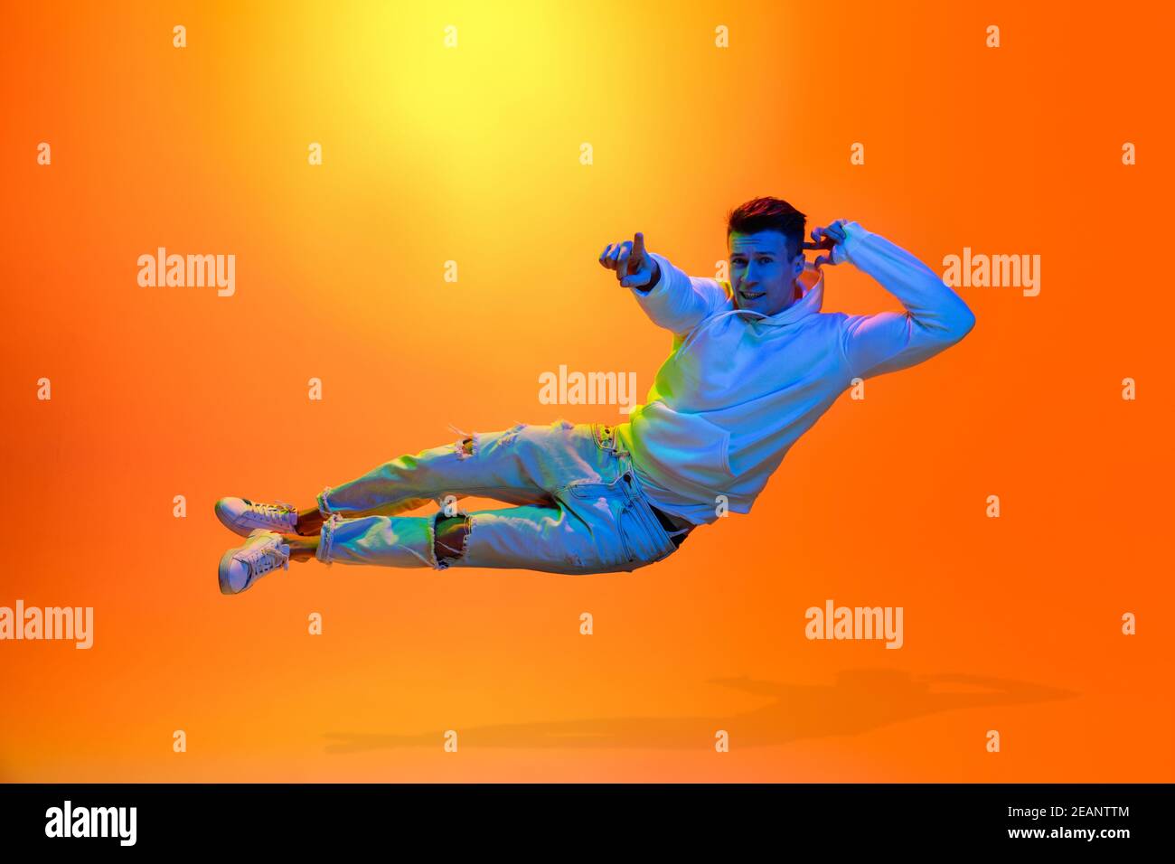 Levitating. Caucasian man's portrait isolated on yellow studio ...