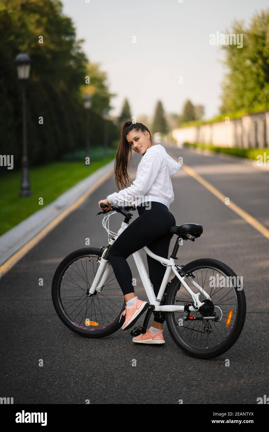 Beautiful girl posing at white bicycle. Walk in nature Stock Photo - Alamy