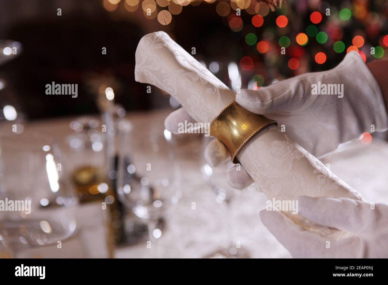 A white-gloved waiter holds a tissue napkin and a vintage ring in her ...