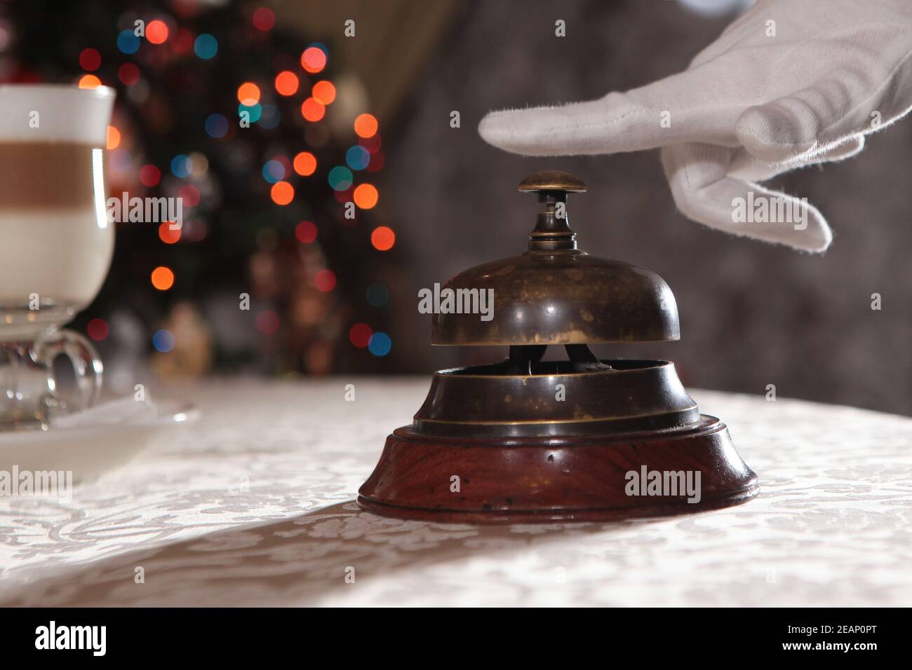 Antique bell for calling the waiter. White-gloved hand. The concept of ...