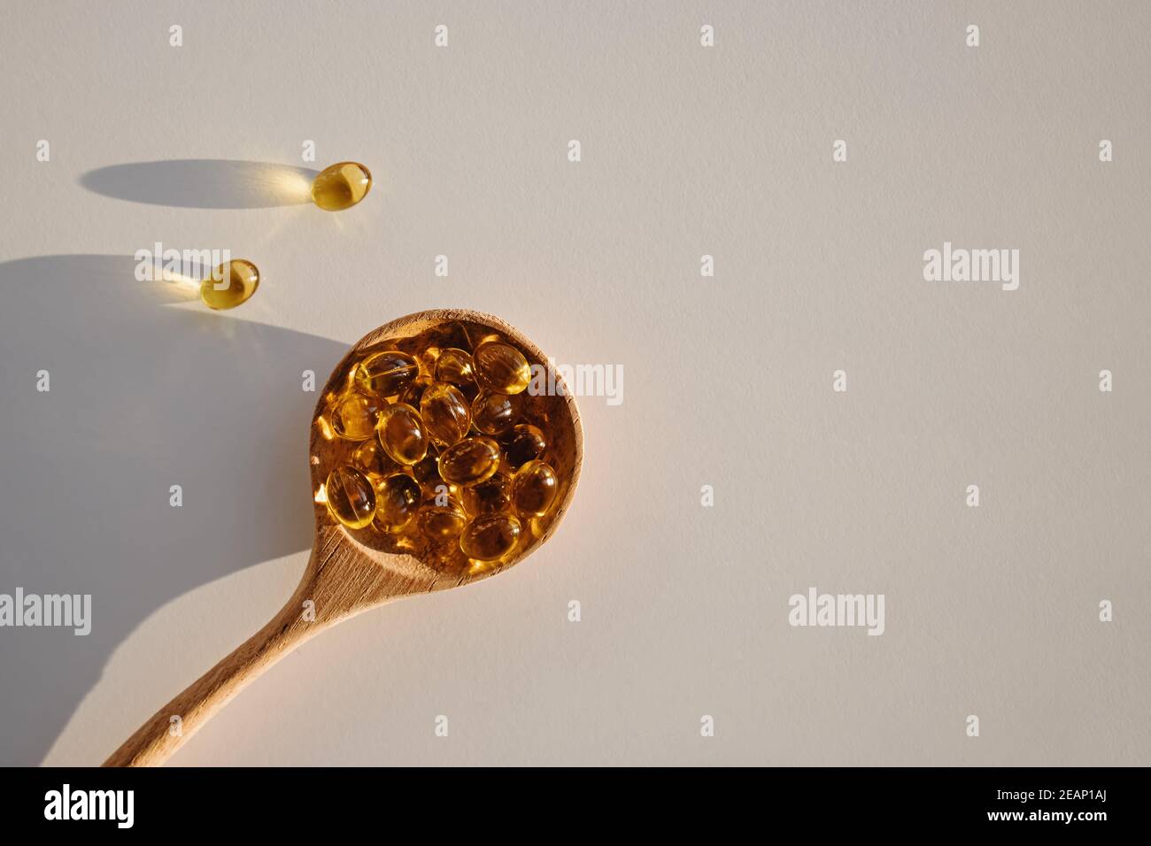 Capsules with vitamin D in wooden spoon Stock Photo - Alamy
