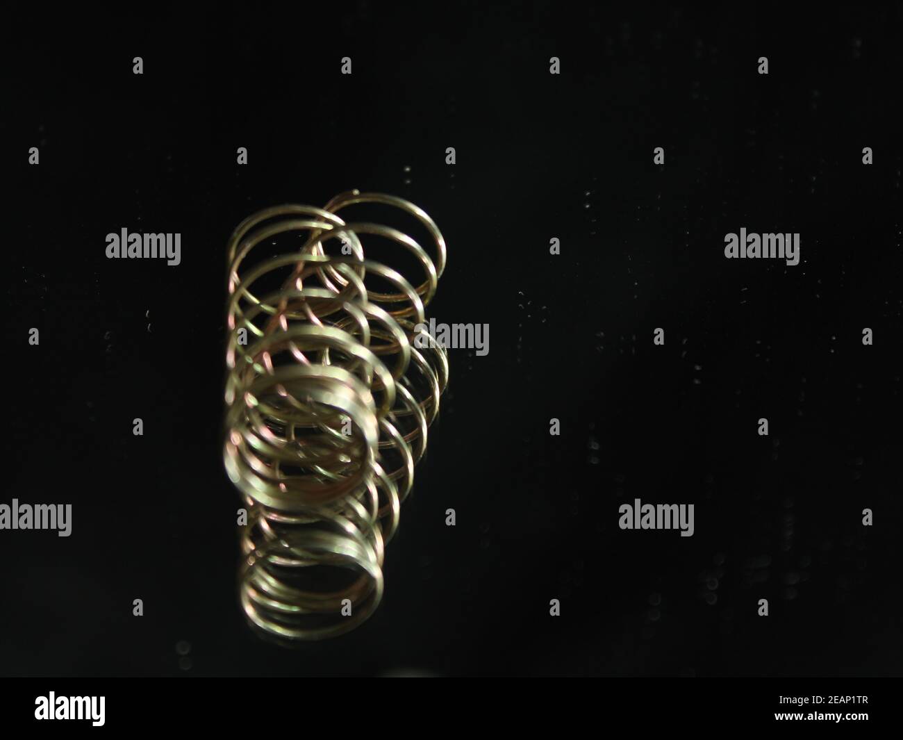 Metal spring round helical spiral reflection elastic Stock Photo - Alamy