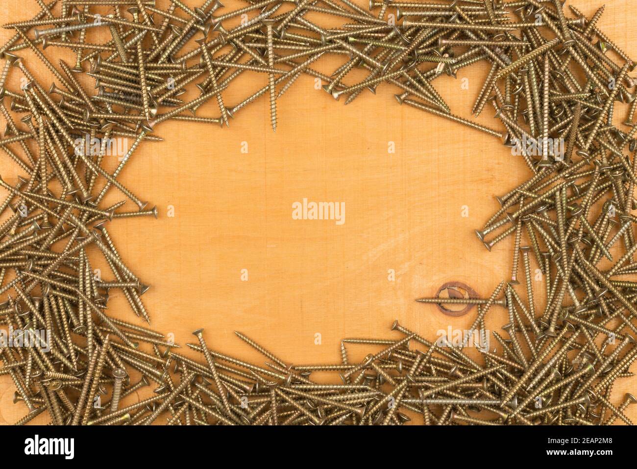 Frame made of screws on a wooden background, copy space. With space for ...