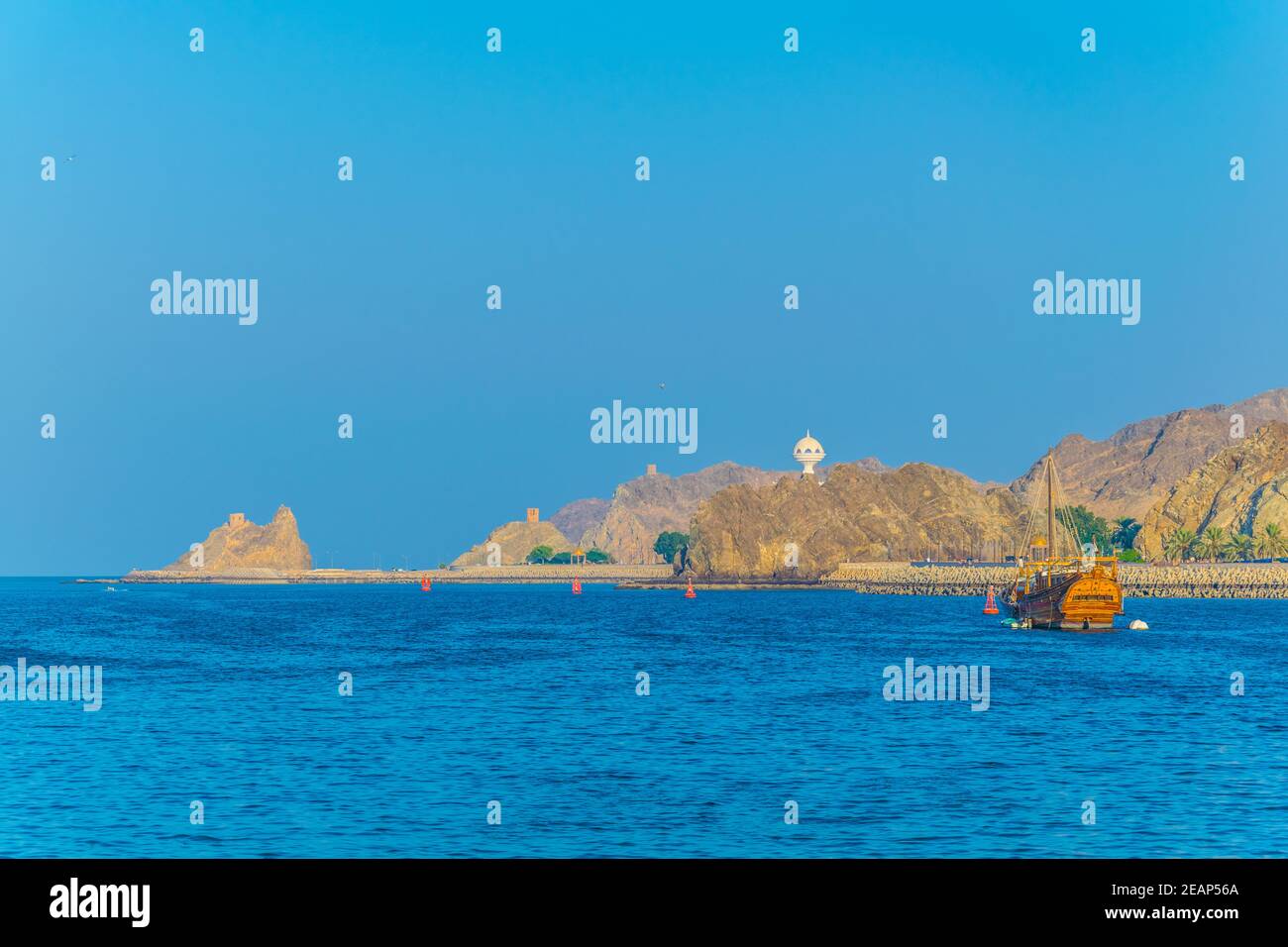 a pair of dhows - traditional arab ships - is heading to the sea from ...