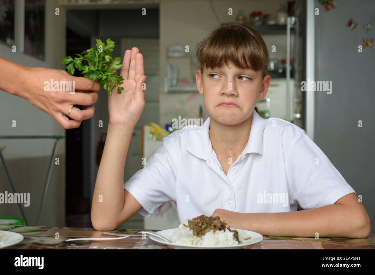 The girl does not want to eat fresh herbs at lunch Stock Photo - Alamy