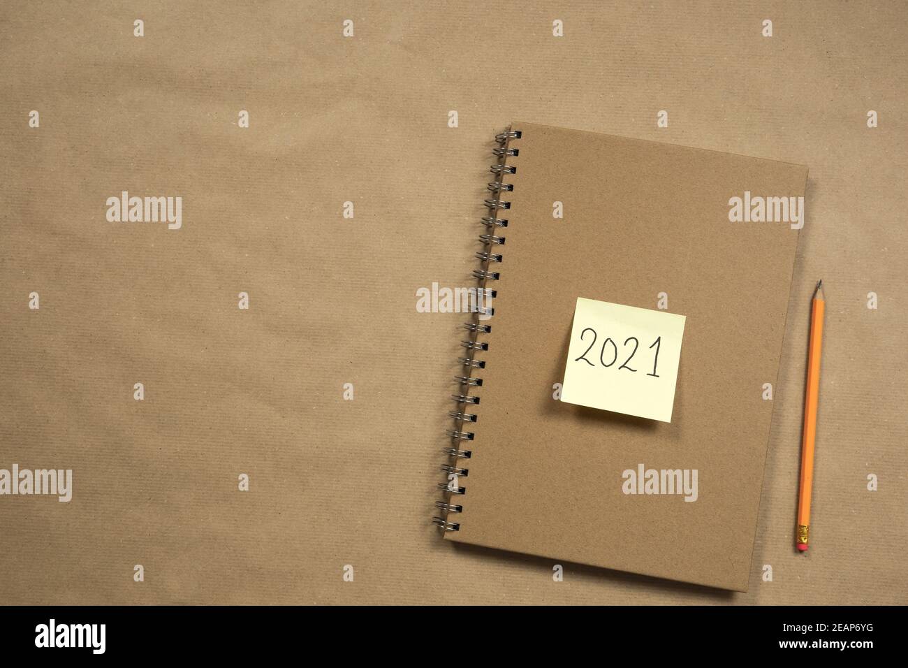 Top view of Brown notepad and yellow sticky note with 2021 New Year's ...