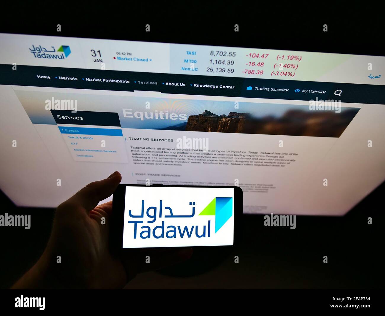 Person holding cellphone with business logo of Saudi Arabian stock ...