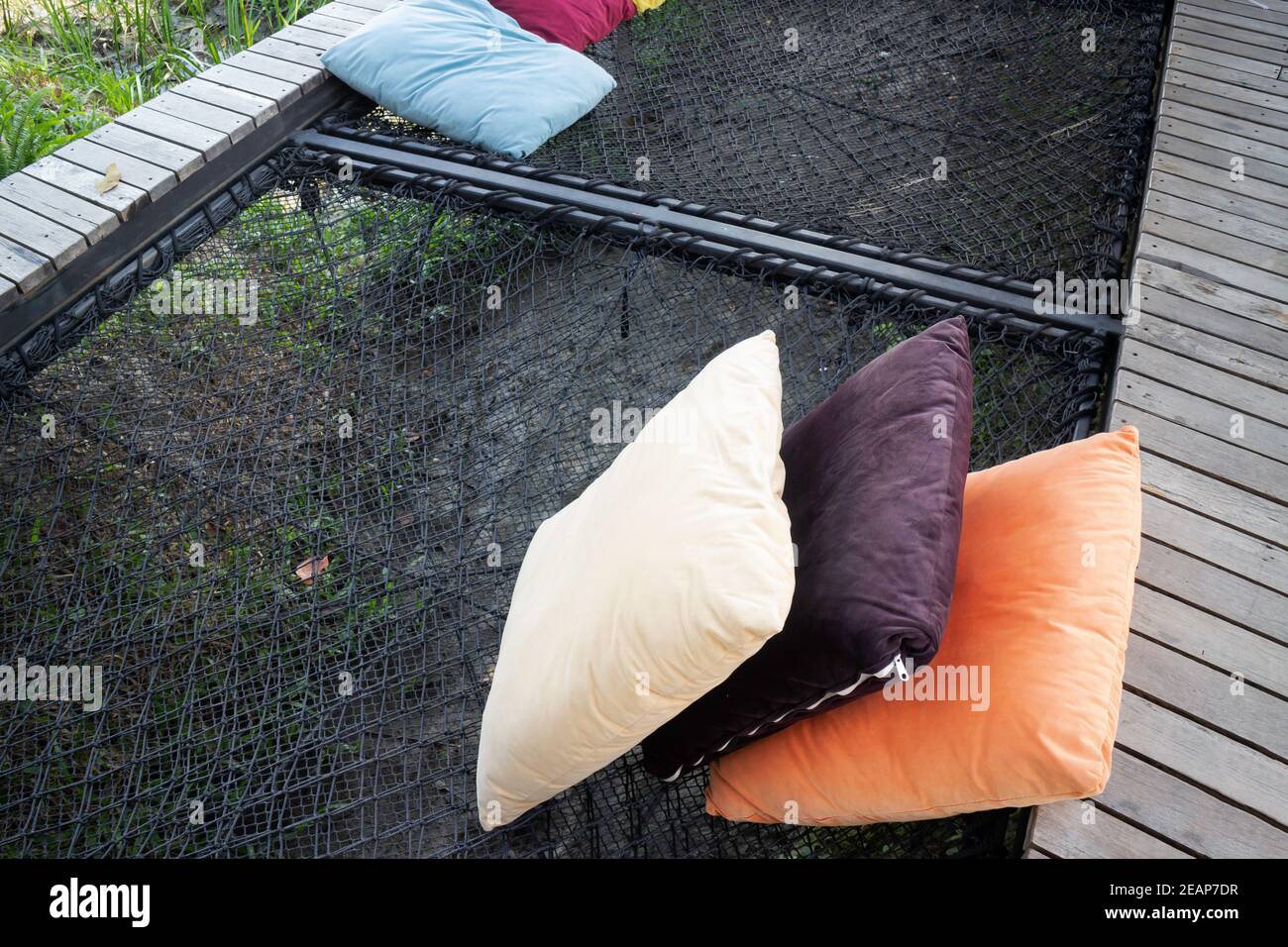 Colorful pillows on net seat among nature Stock Photo - Alamy
