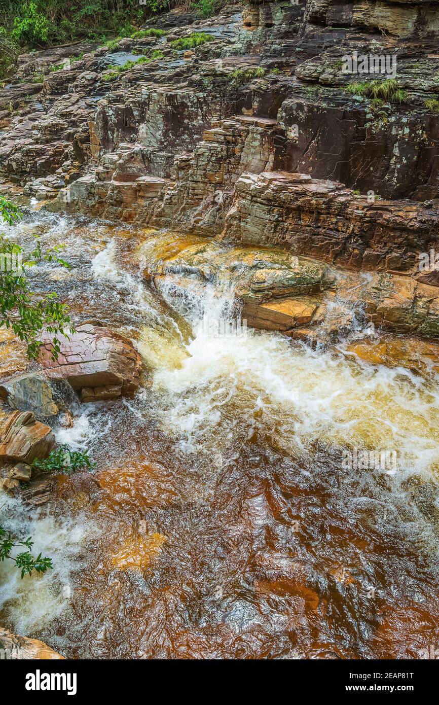 Water stream of a river running by the sedimentary rocks, water with ...