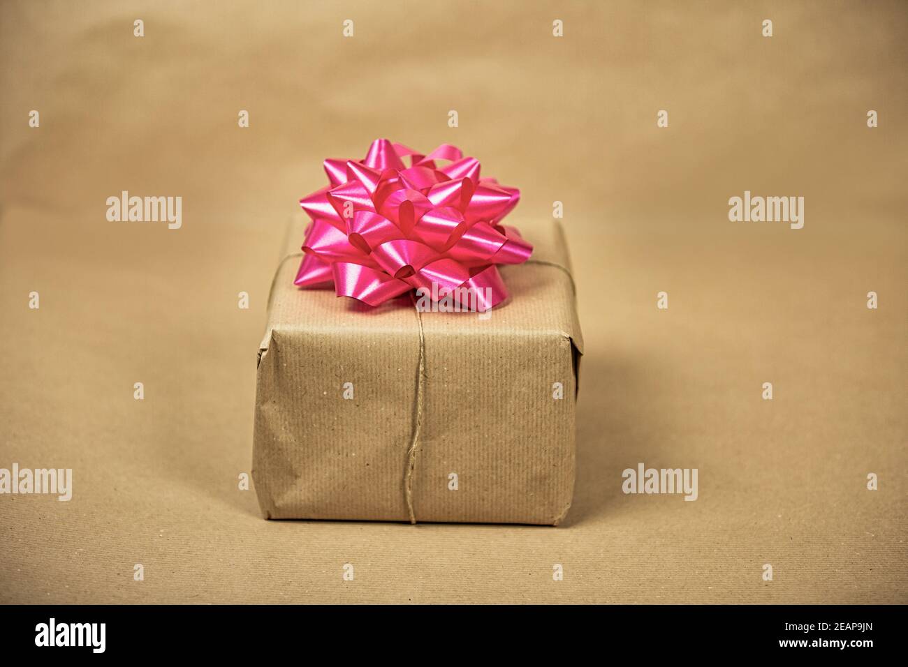 Brown plain paper gift box with pink wrapping decoration on brown ...