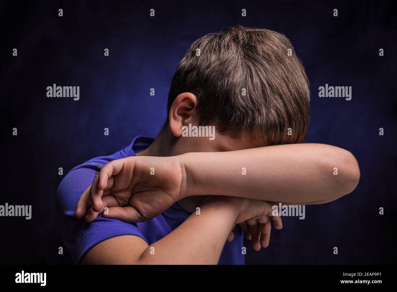 sad european teenage boy with light brown hair in sports purple t-shirt ...