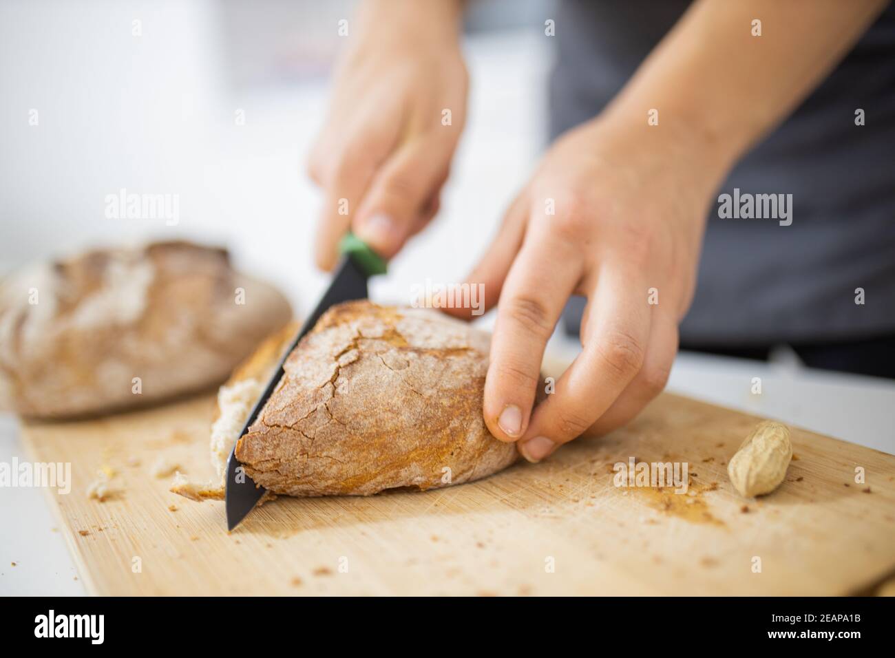 Female hands slicing bread on a cutting board Stock Photo - Alamy