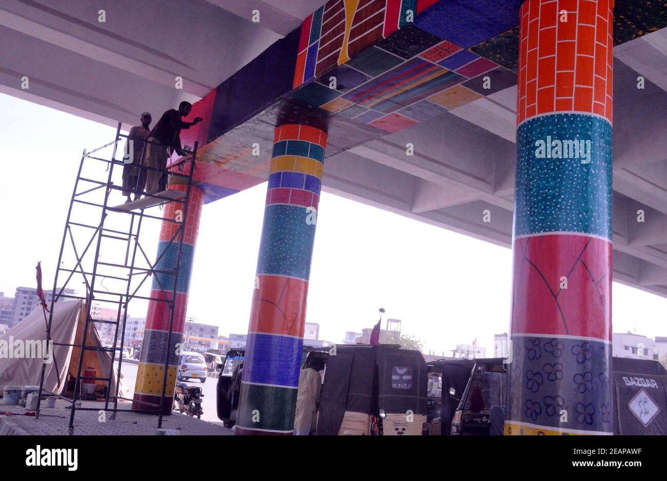 Laborers are busy in art painting on pillar wall of a bridge for the ...