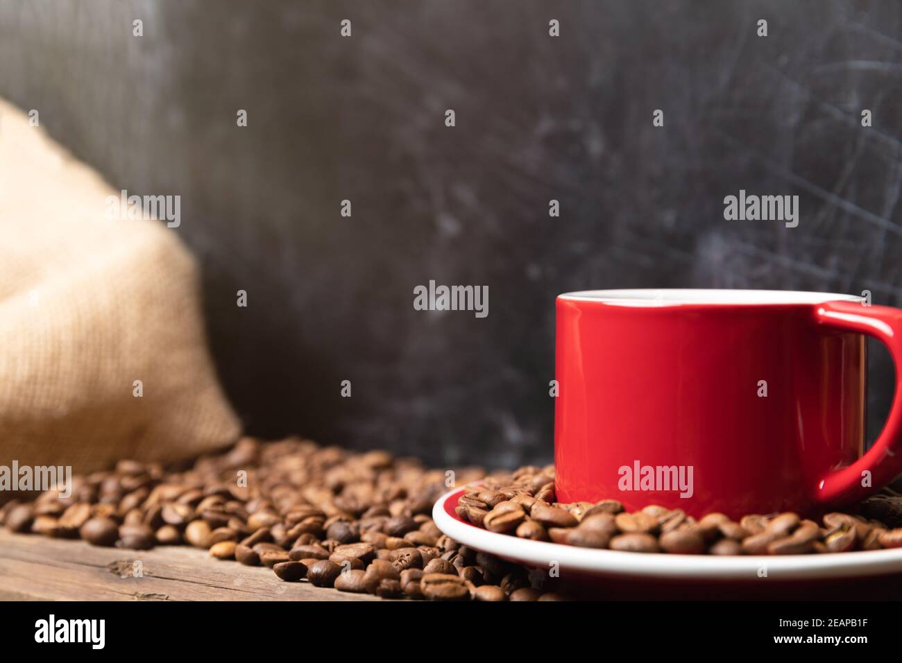 Red cup of coffee with coffee beans on dark textured background ...